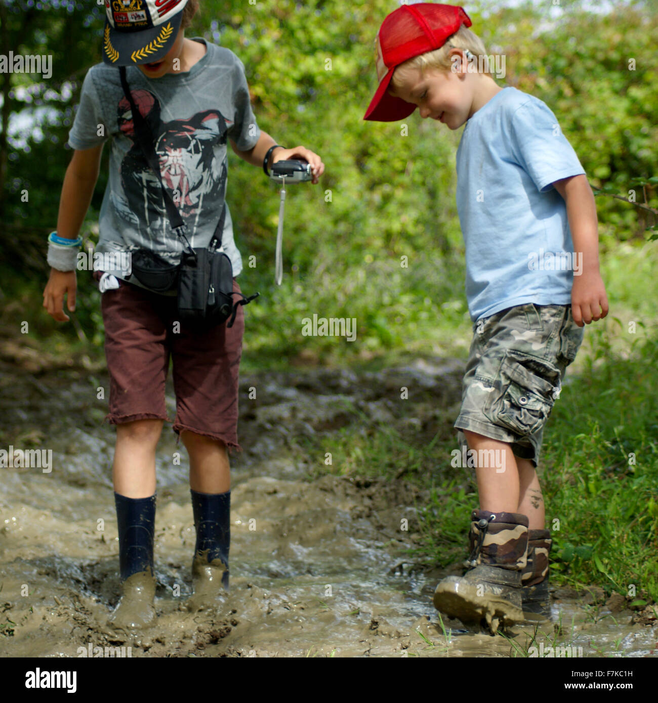Jungs spielen im Schlamm, Kinder spielen im schlammigen Pfütze ...