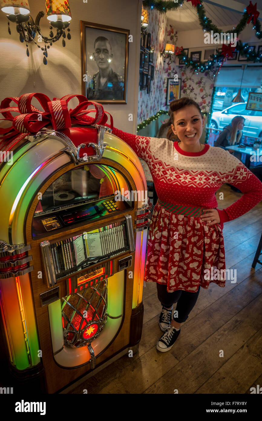 Retro Cafe mit jungen Frau an eine Jukebox in einem Weihnachten Jumper ...