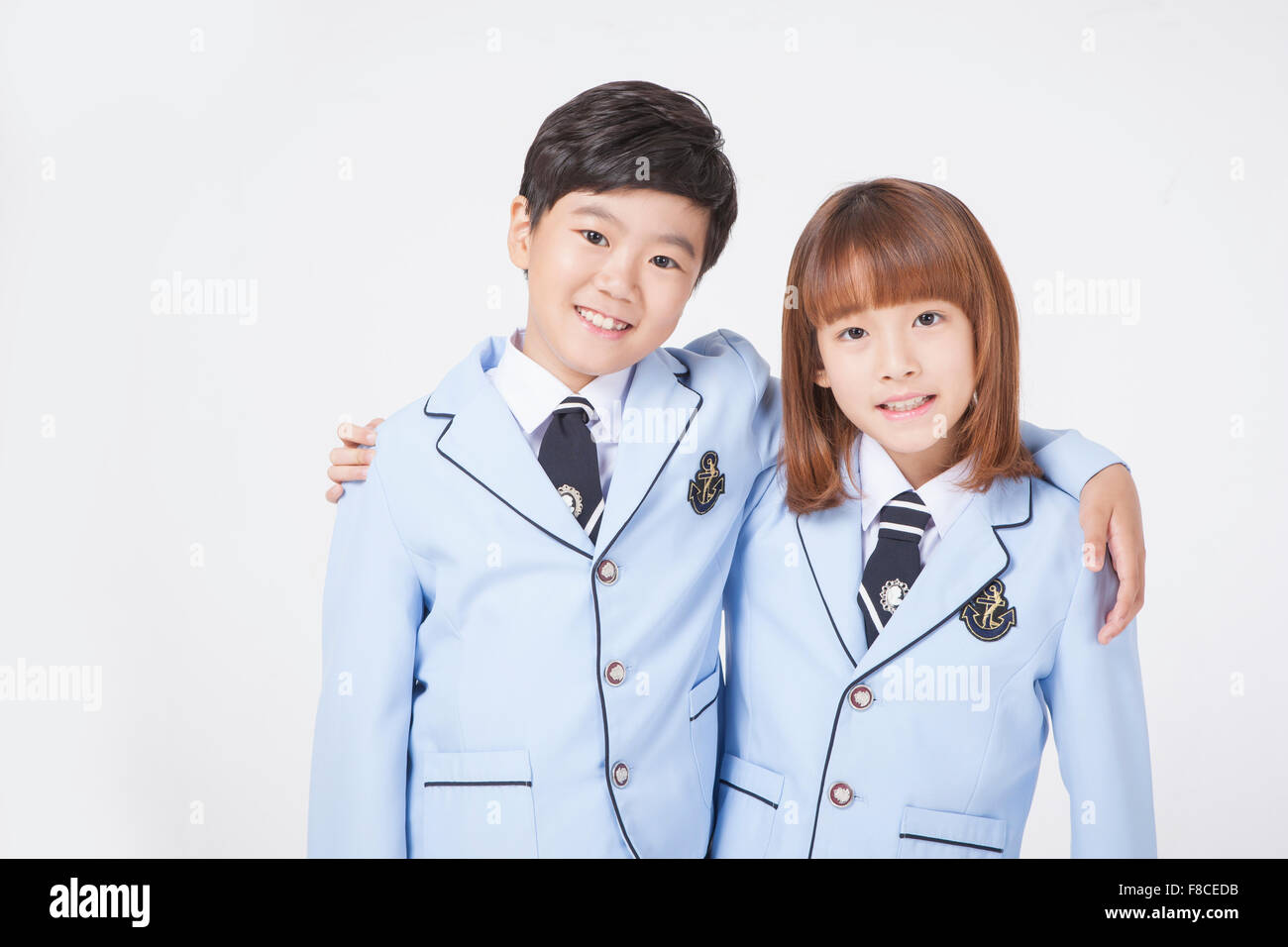 Grundschule-jungen und Mädchen in Schuluniformen mit ihre Arme umeinander und starrte nach vorne ...