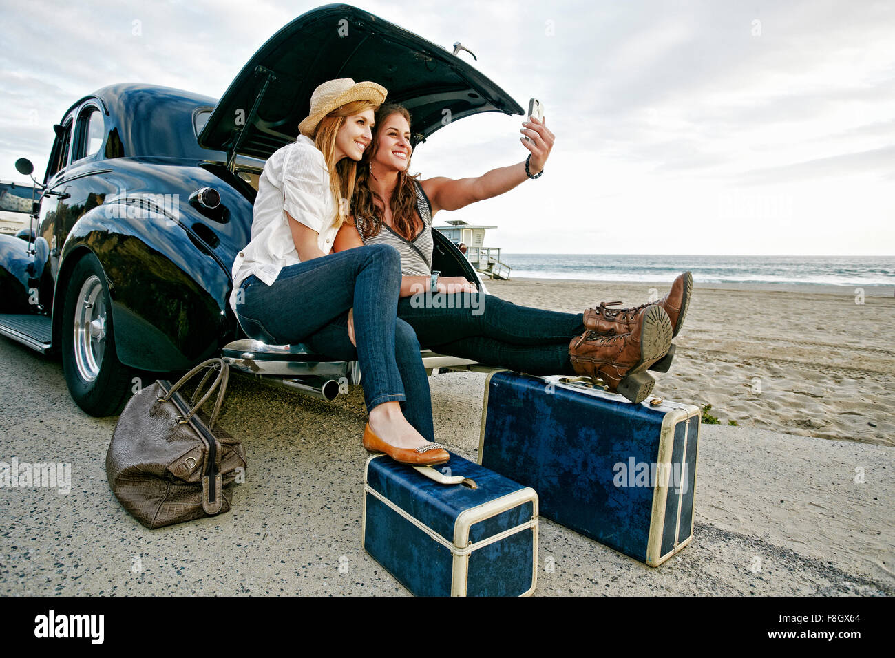 Frauen mit Gepäck und Vintage Auto am Strand Stockfotografie - Alamy