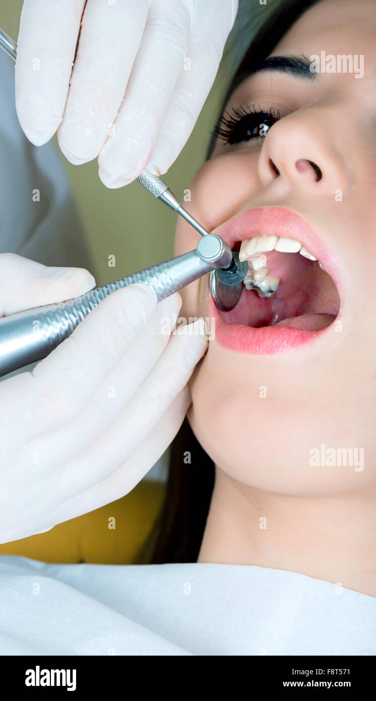 junge Frauen beim Zahnarzt in den Behandlungsstuhl sitzt ein Arzt tun beim Zahnarzt zu sehen, ob ...