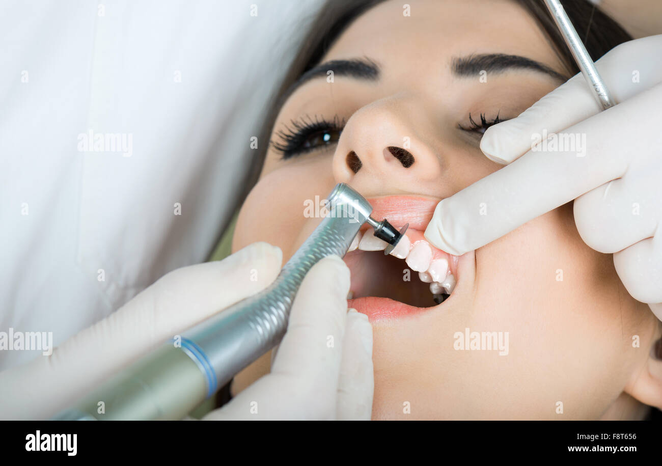 junge Frauen beim Zahnarzt in den Behandlungsstuhl sitzt ein Arzt tun beim Zahnarzt zu sehen, ob ...