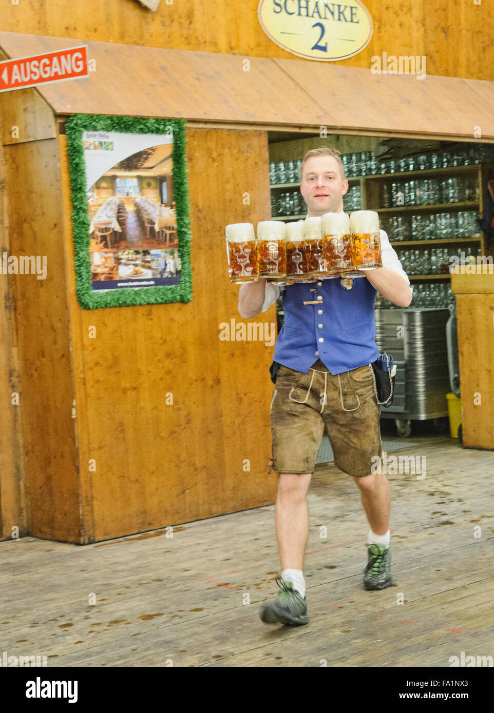 Kellner in einem traditionellen Lederhosen tragen riesige Gläser Bier ...