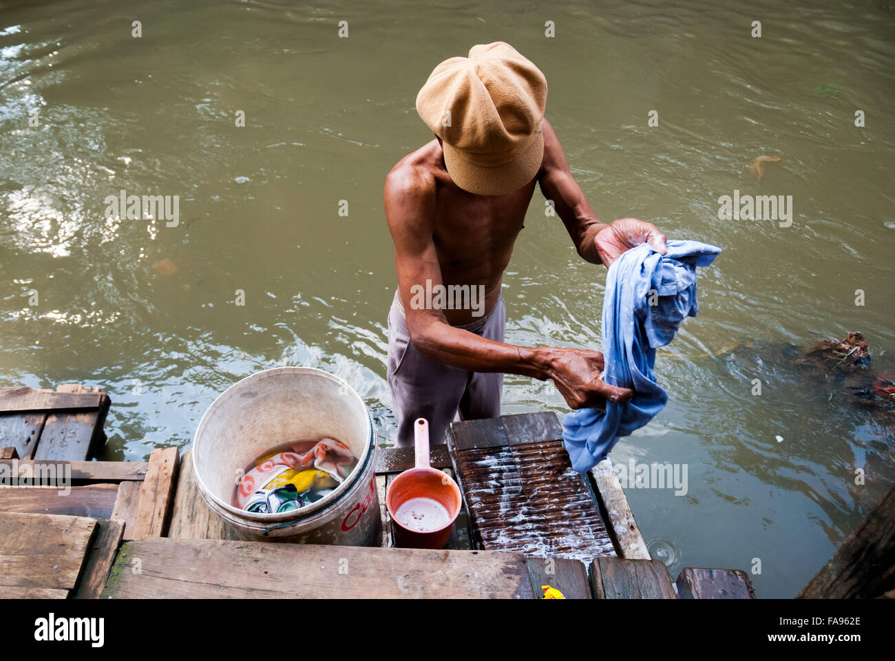 Man Wäsche waschen am Ciliwung riverbank, Jakarta. Ciliwung ist als ...