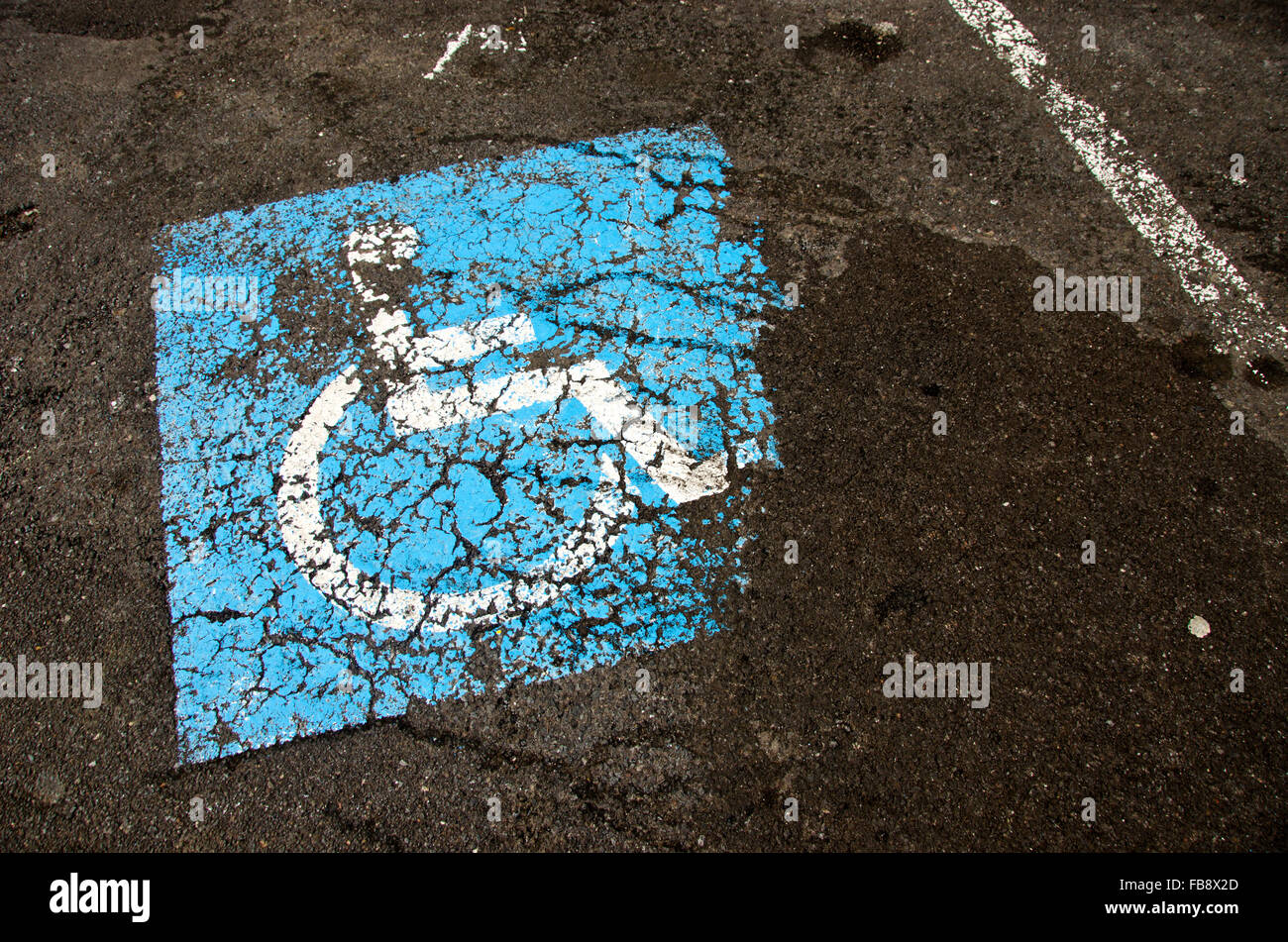 Blaue und weiße Behinderung Zeichen auf alte rissige asphalt ...