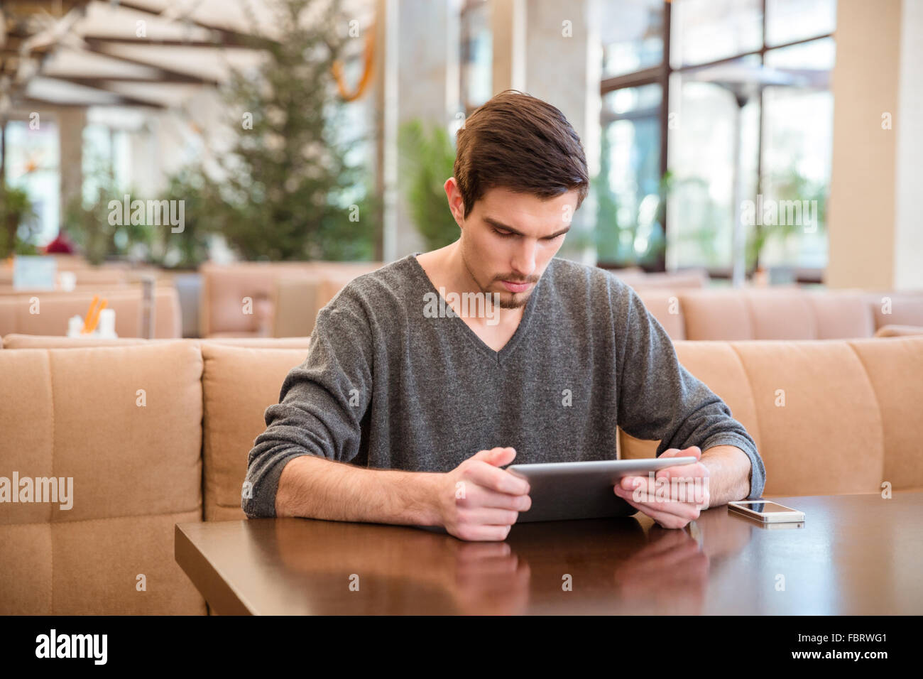 Junger mann am tisch sitzen -Fotos und -Bildmaterial in hoher Auflösung ...