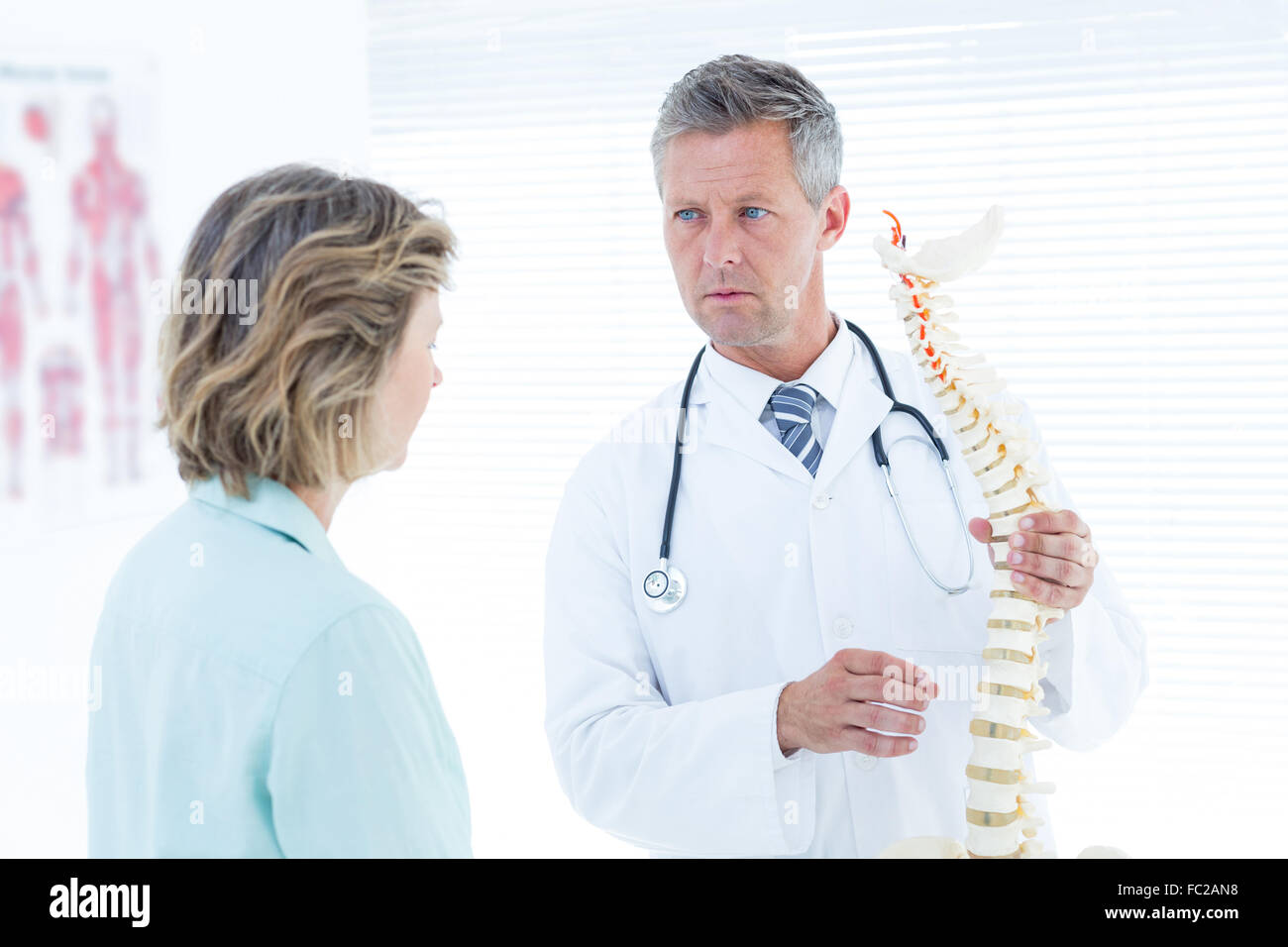 Arzt Gespräch mit seinem Patienten und Wirbelsäule Modell zeigen ...