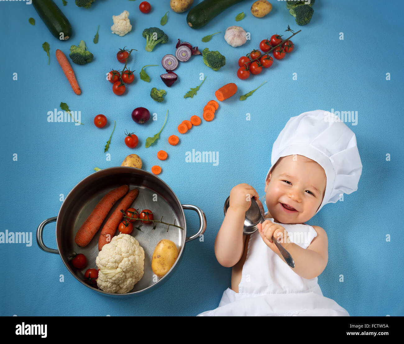 Baby Boy in Koch Hut mit Kochen Pfanne und Gemüse Stockfotografie - Alamy