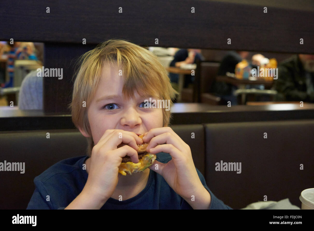 Boy eat burger -Fotos und -Bildmaterial in hoher Auflösung – Alamy