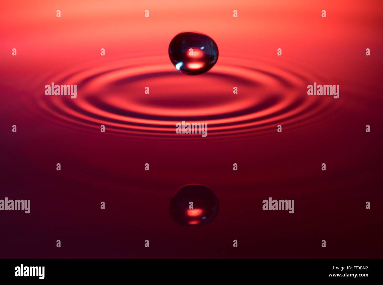 Ein Tropfen Wasser auf die Reflexion in einer Lache des Wassers ...