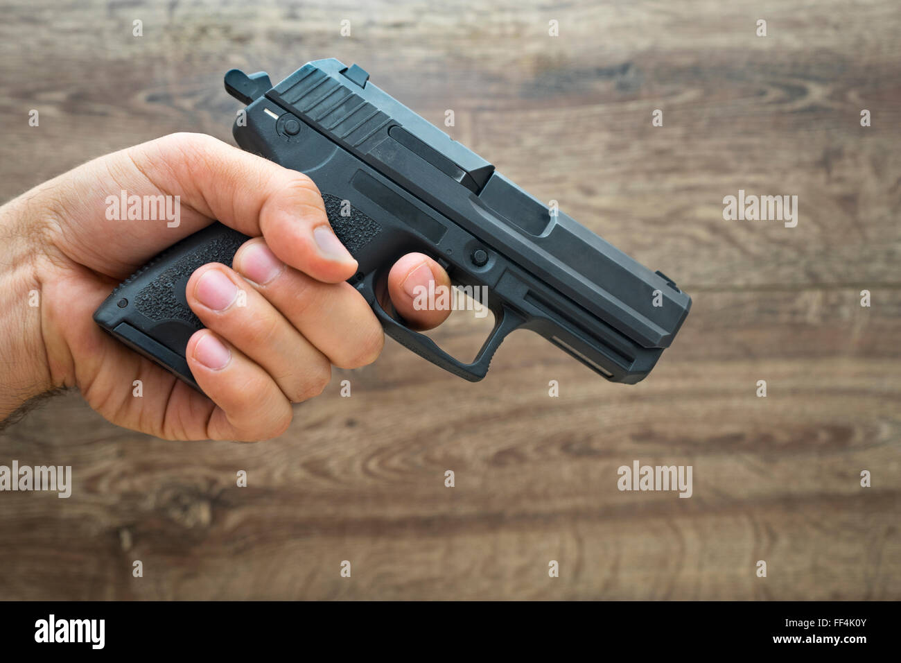 Μasculine Hand mit Pistole Pistole, Wedel aus Holz Hintergrund ...