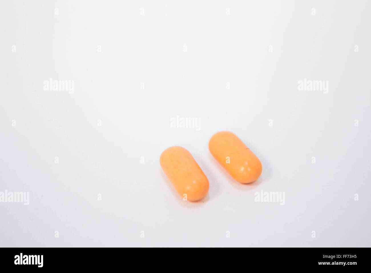 Zwei orange Tabletten antibiotische Medikation. Diese Tabletten sind ...
