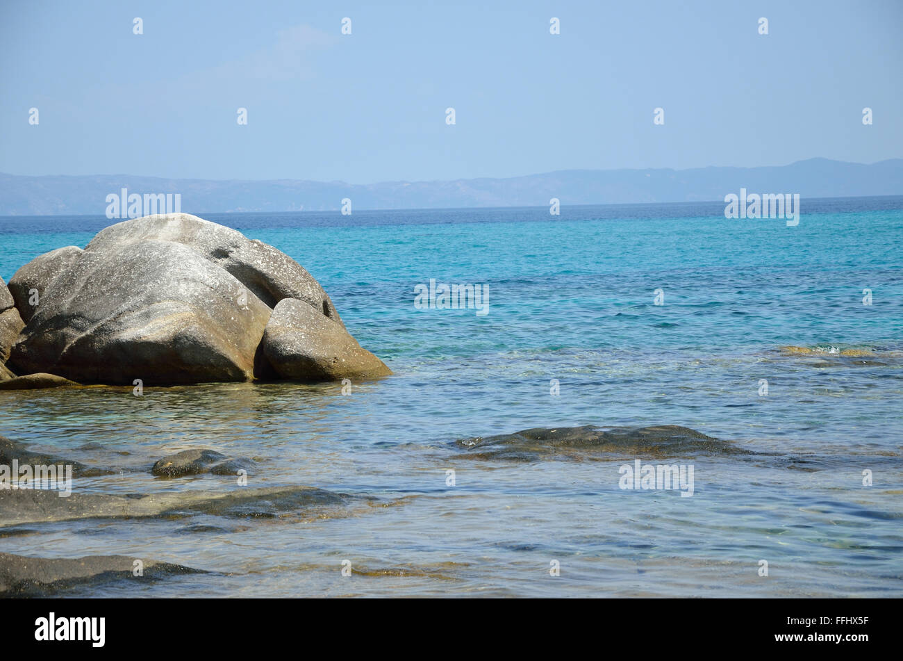 Großer Stein steigt aus dem blaues Meer in Griechenland Stockfotografie ...