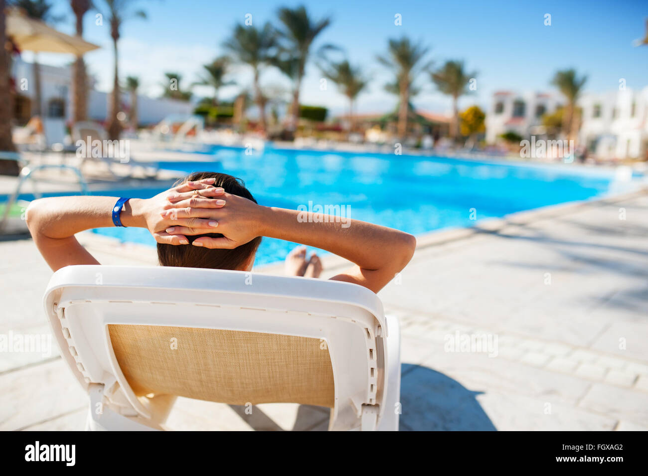 glückliche Frau liegend auf einer Liege am Pool im hotel ...