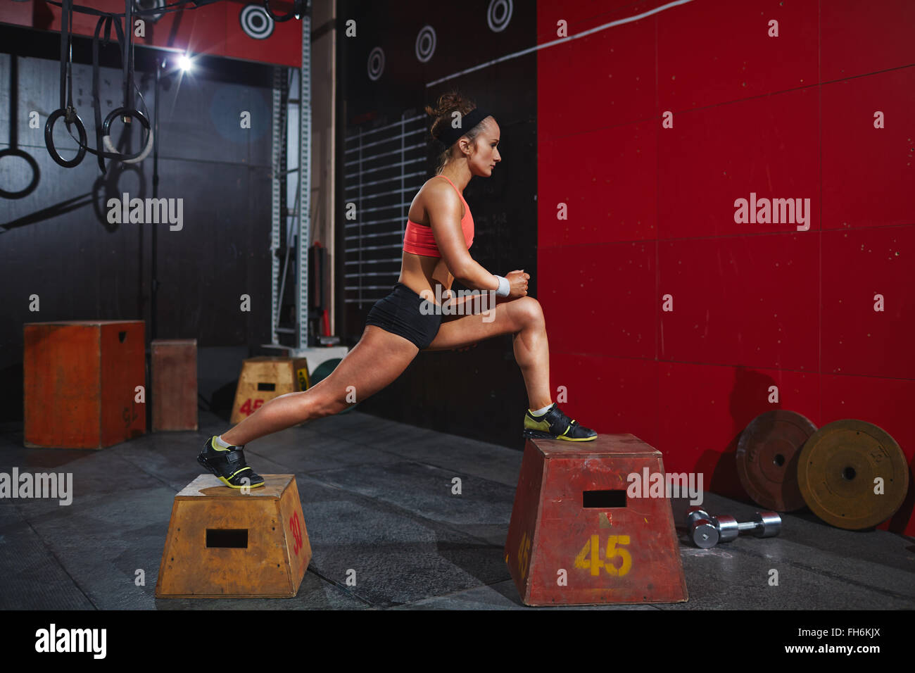 Junge Frau im Active-Wear-Training am Sprung-Boxen im Fitness-Studio ...