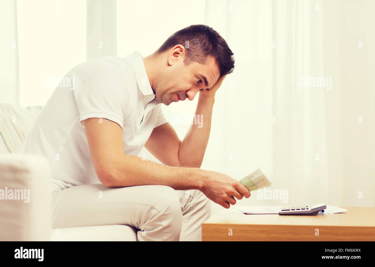 Mann mit Geld und Rechner zu Hause Stockfotografie - Alamy