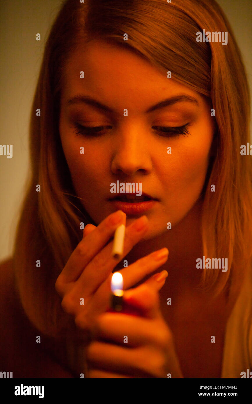 Sucht. Junge Frau mit Feuerzeug Anzünden der Zigarette. Süchtig Mädchen ...