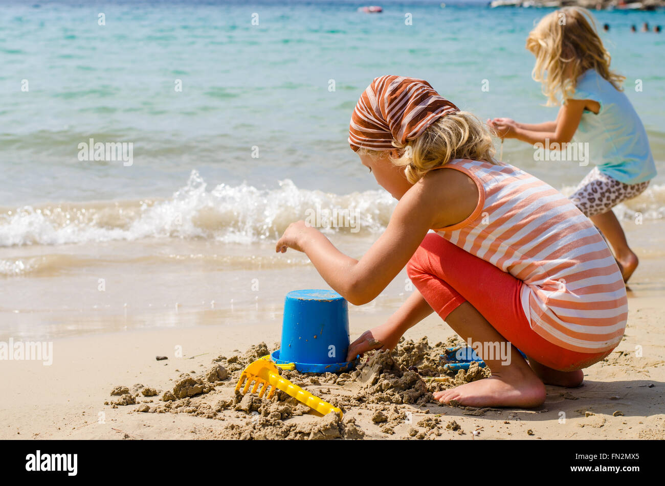 zwei Kinder spielen mit Sand am Strand Stockfotografie - Alamy