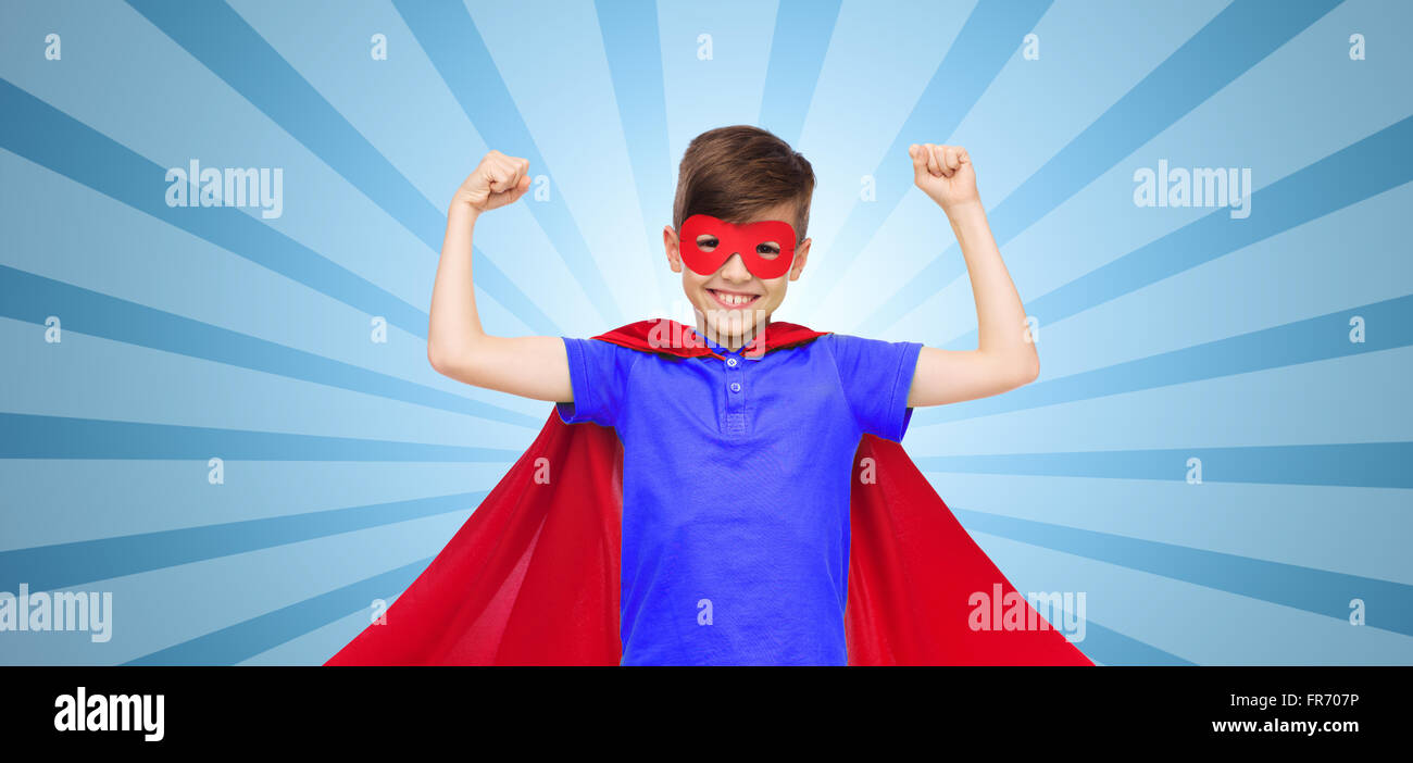 Junge im roten Superhelden Cape und Maske zeigt Fäuste Stockfotografie ...
