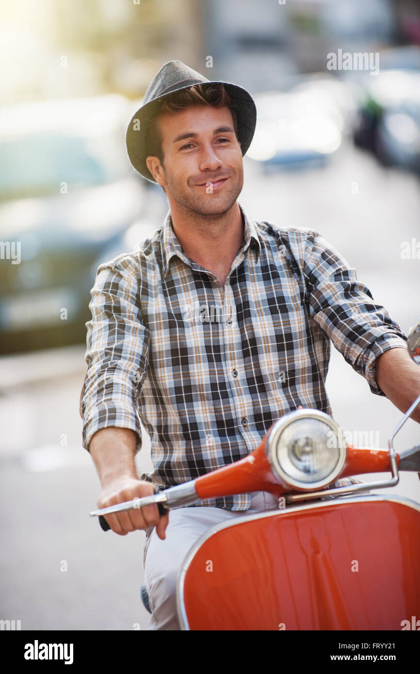 gut aussehender Mann mit dem Hut ein Vintage Scotter auf der Straße ...