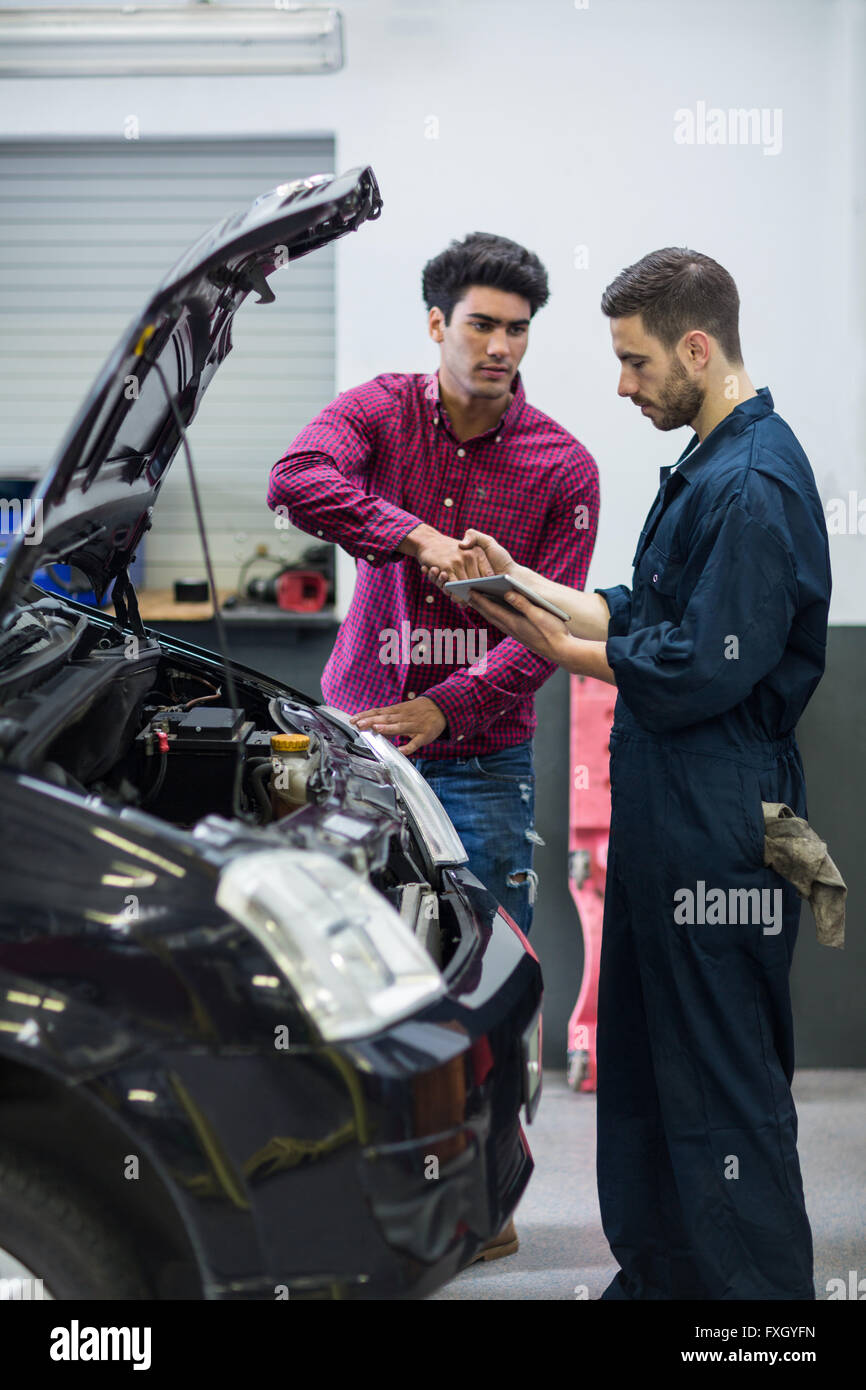 Kunden, die das Händeschütteln mit Mechaniker Stockfotografie - Alamy