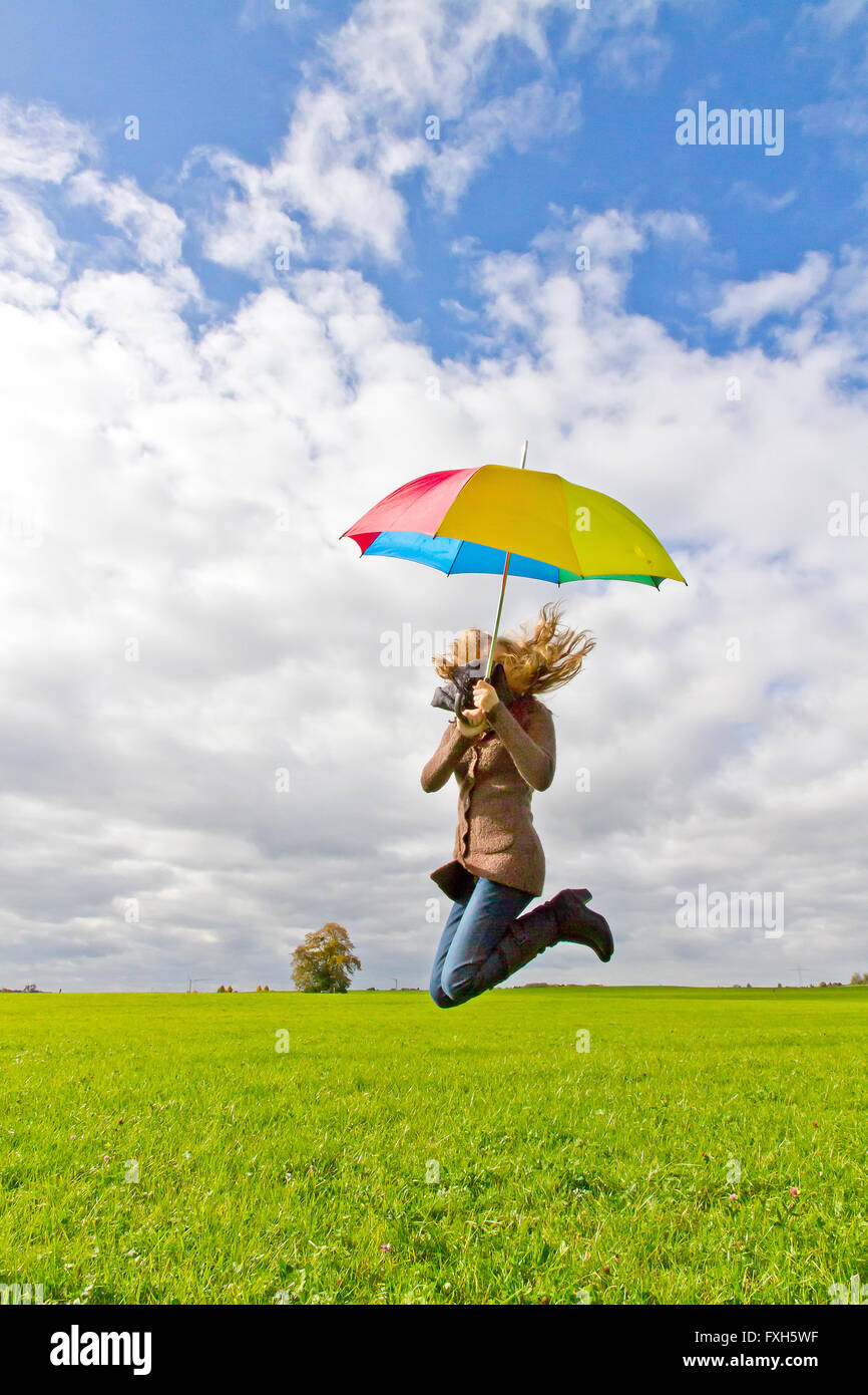 Eine junge Frau mit ihrem Schirm hoch springen Stockfotografie - Alamy