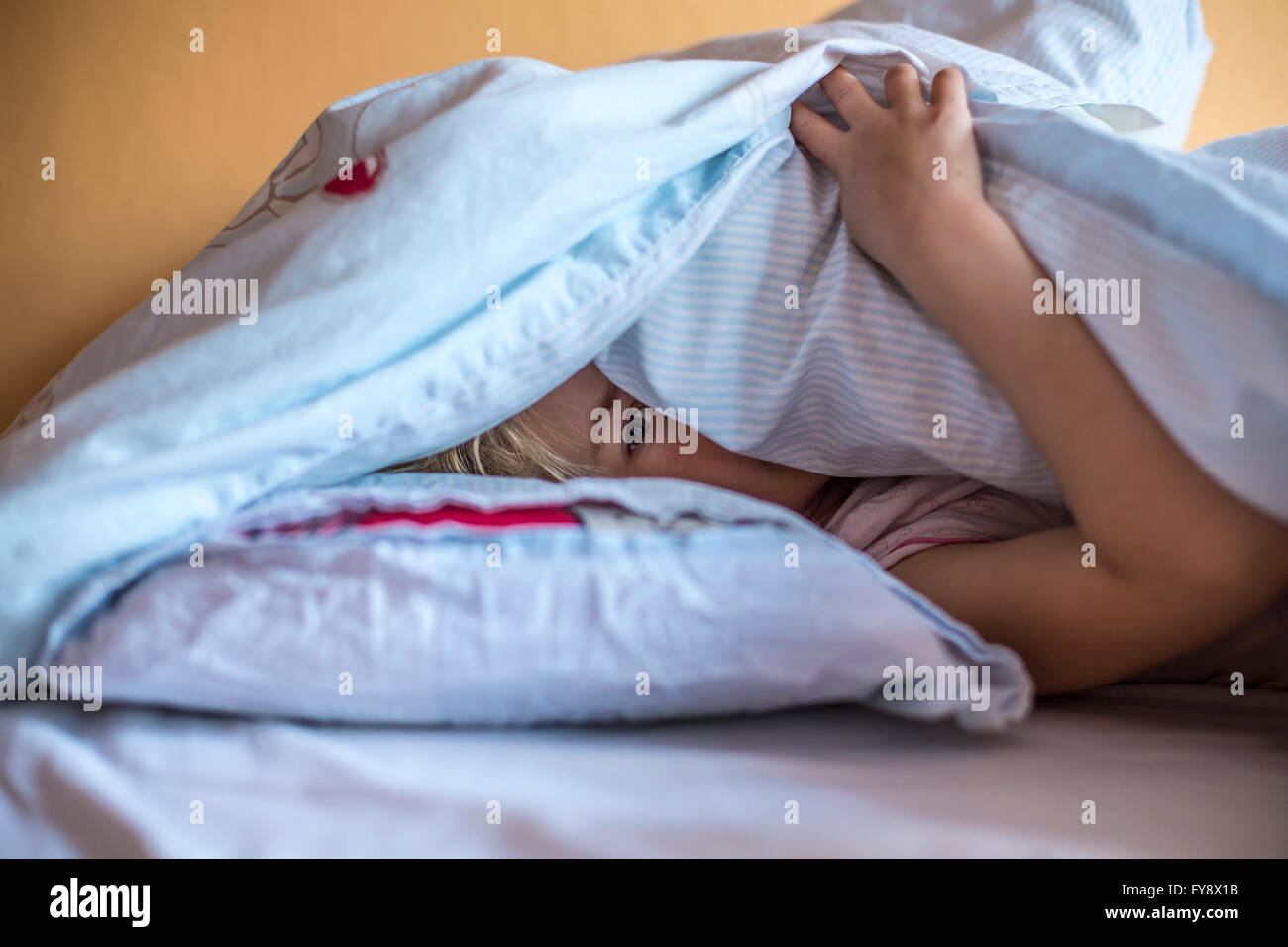 Kleines Mädchen versteckt unter der Decke Stockfotografie - Alamy