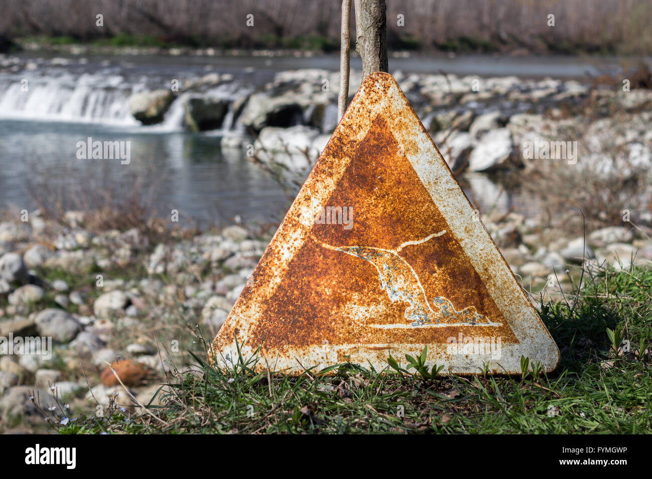 Verlassene Straße Verkehrsschild mit einer Flut-Warning. Ein Fluss im ...