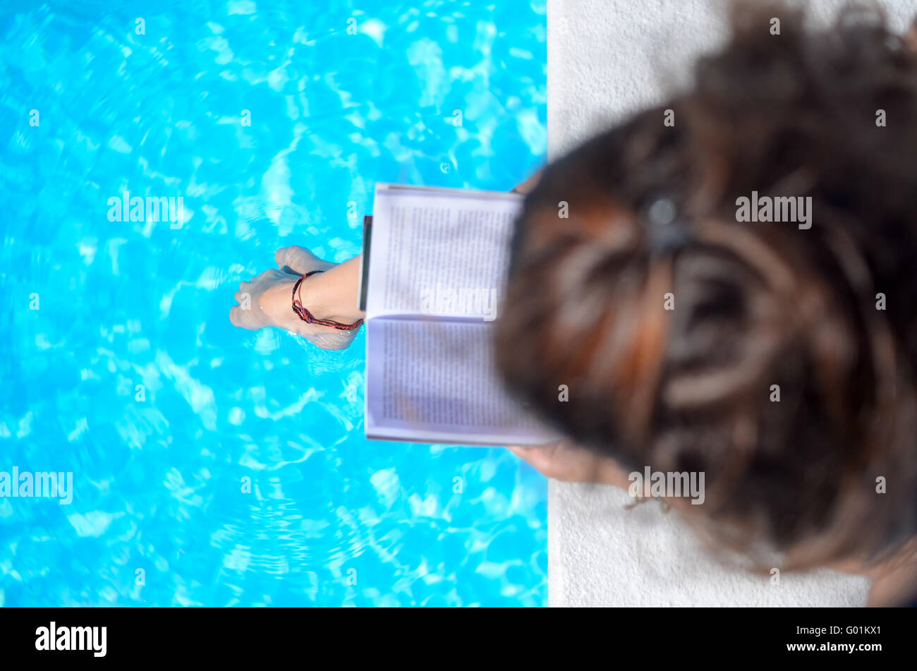 Woman reading book in swimming pool -Fotos und -Bildmaterial in hoher ...