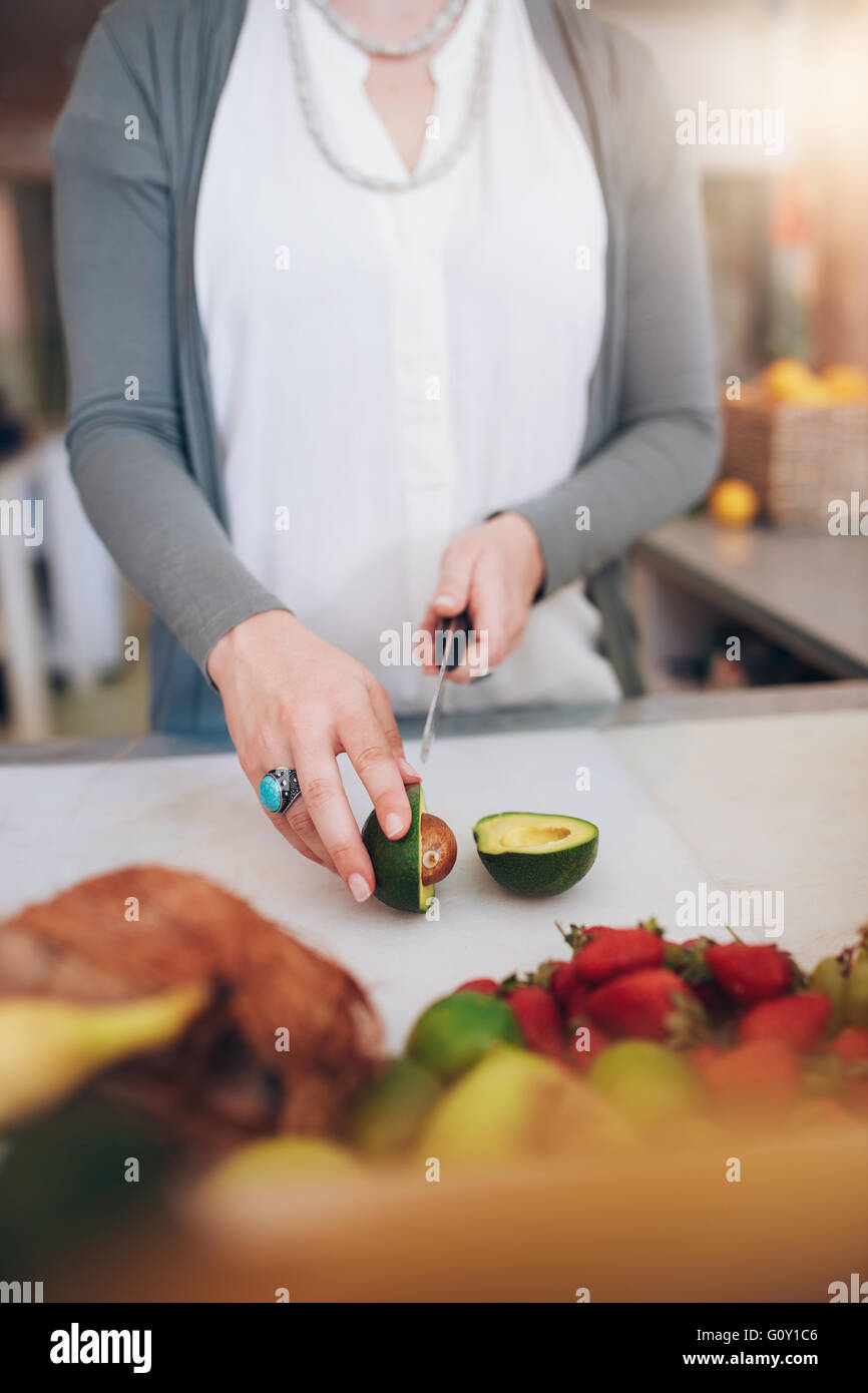 Schuss der Frauenbeschneidung Avocado Frucht am Schalter beschnitten ...