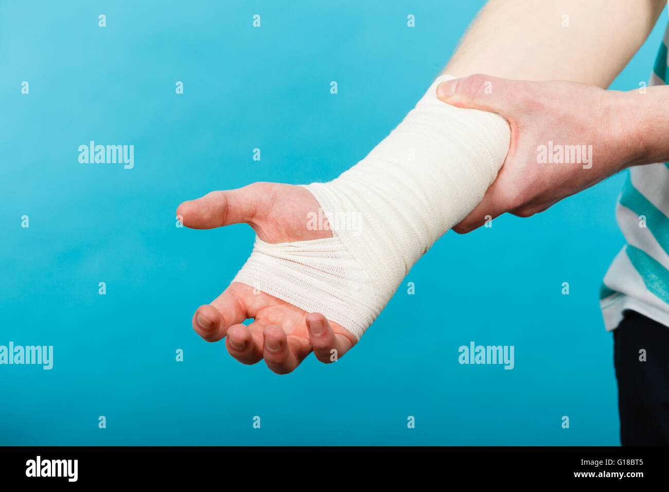 Schmerzen und Verletzungen Konzept. Junger Mann hält bandagierte Hand ...