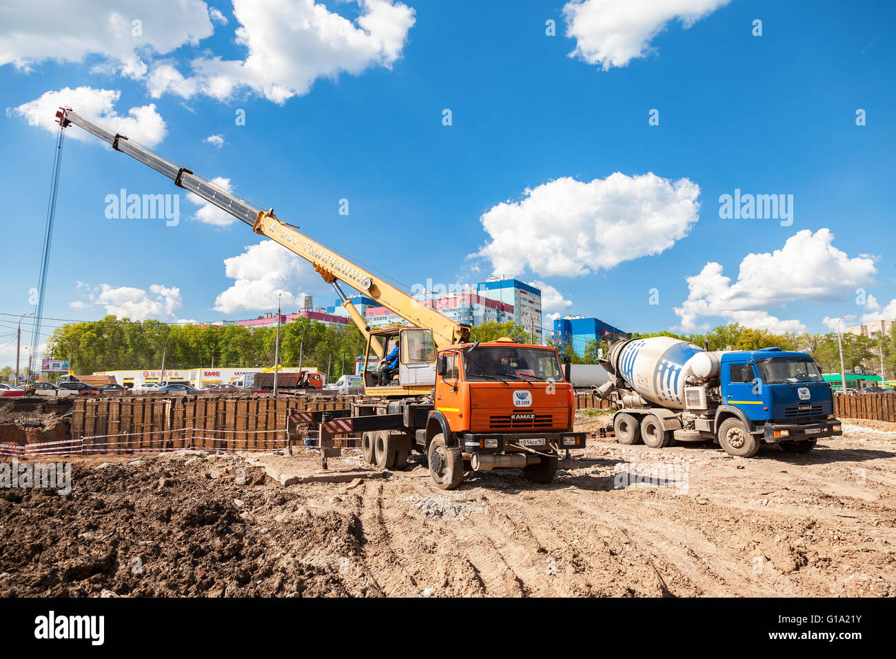 LKW Kran KAMAZ und Betonmischer LKW arbeiten auf der Baustelle ...