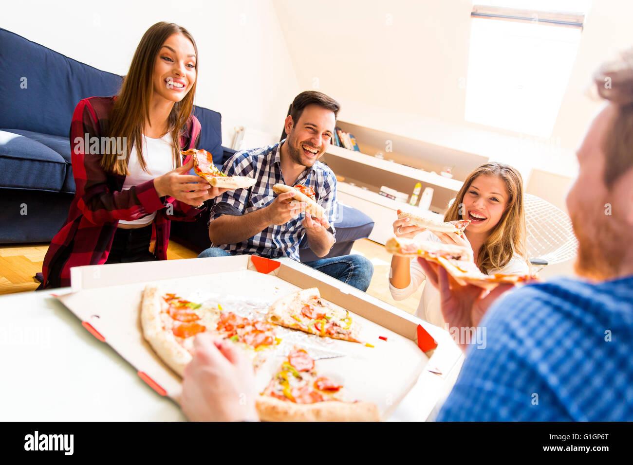 Gruppe von Freunden zu Hause zusammen Pizza essen Stockfotografie - Alamy