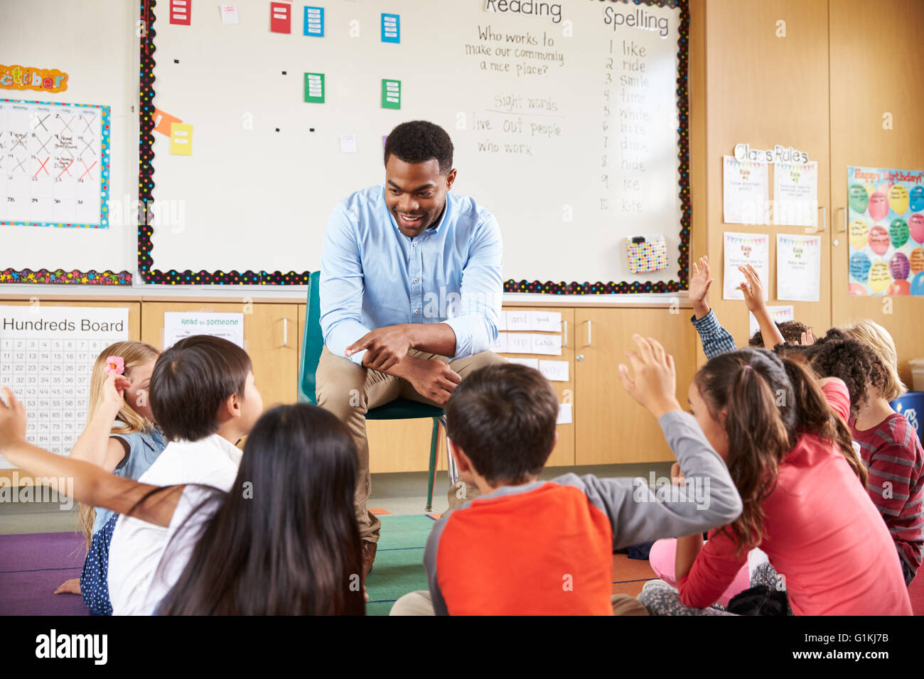Grundschule Kinder sitzen um Lehrer im Klassenzimmer Stockfotografie ...