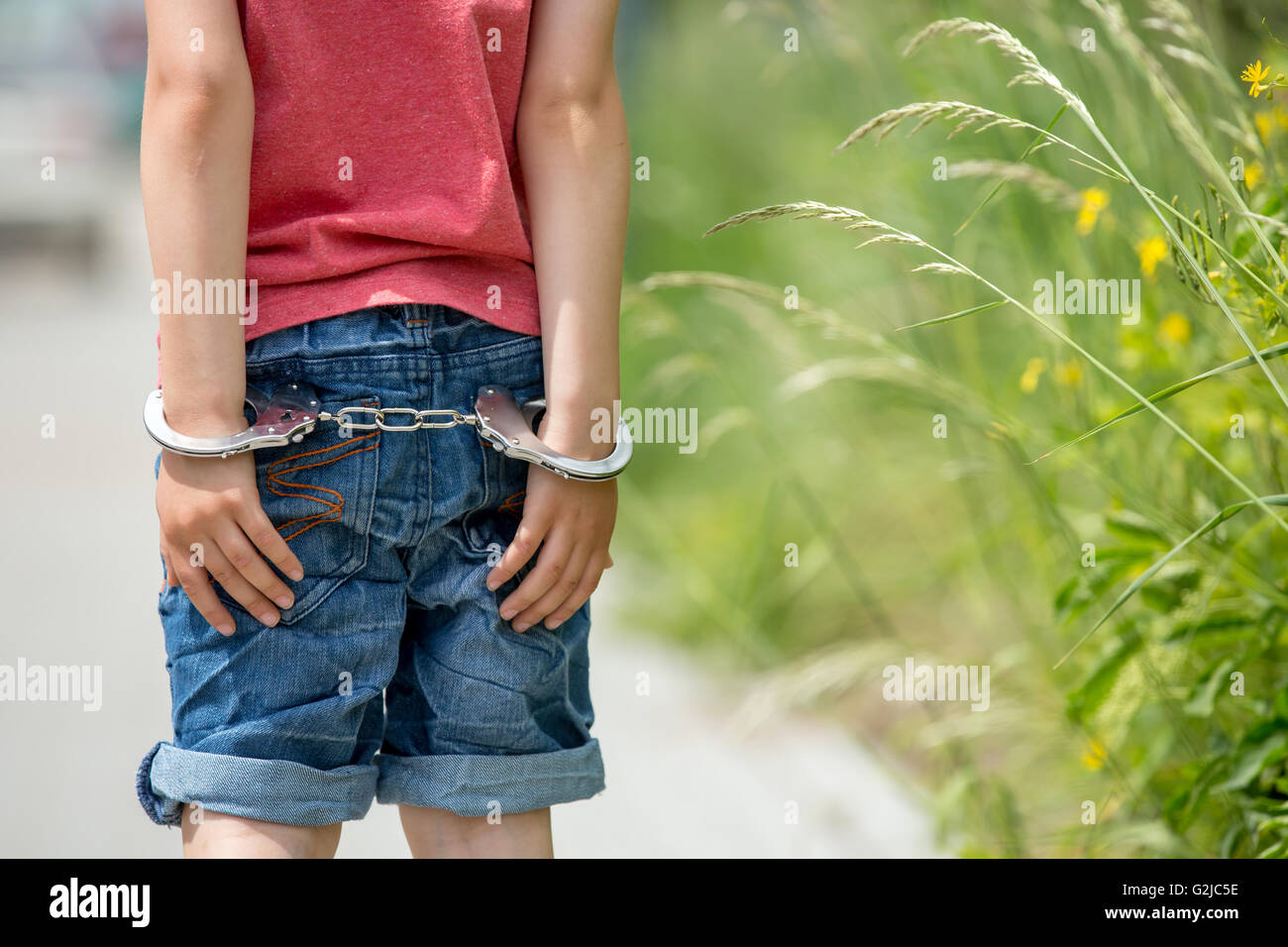 Niedliche kleine Junge mit Handschellen an den Händen, spielen ...