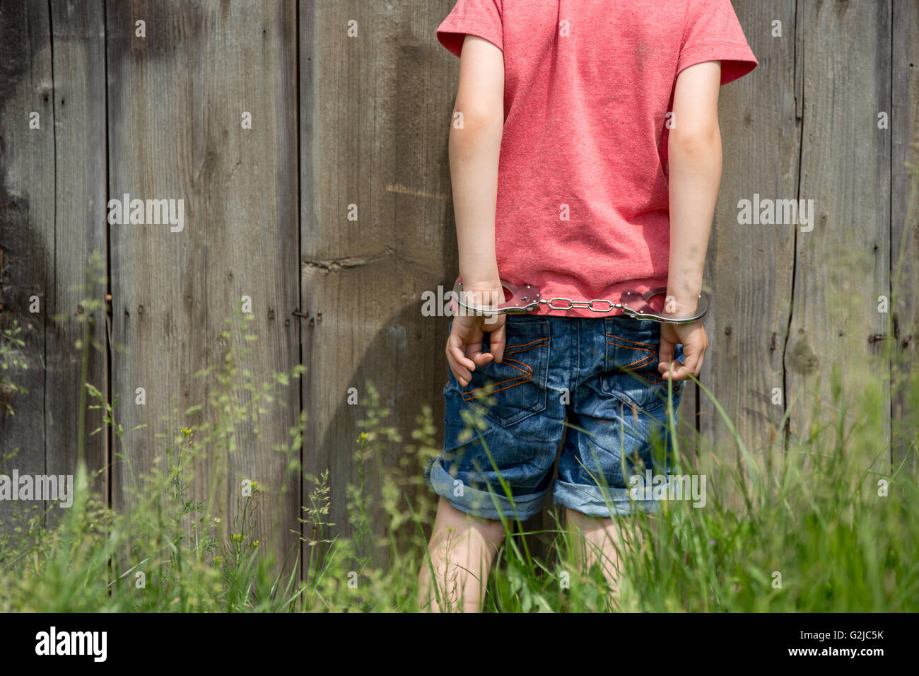 Niedliche kleine Junge mit Handschellen an den Händen, spielen ...