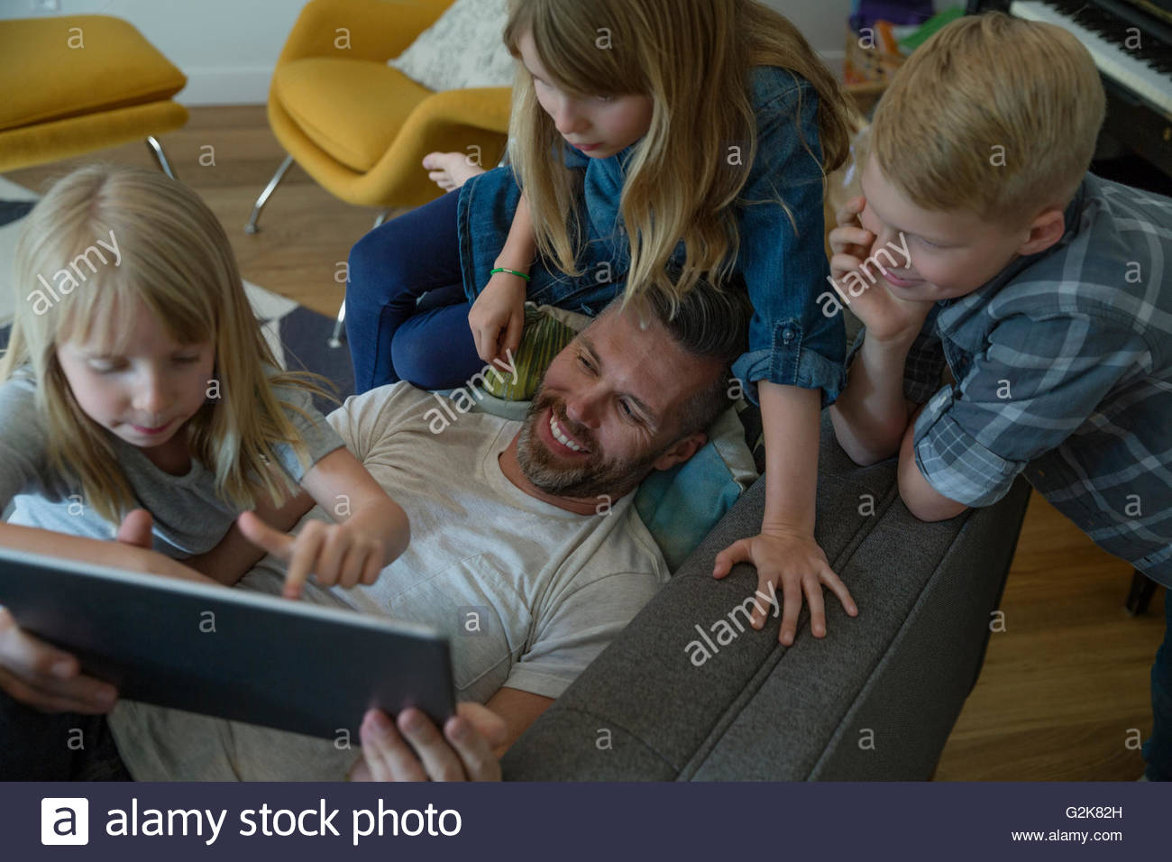 Vater und Kinder mit digital-Tablette auf sofa Stockfotografie - Alamy