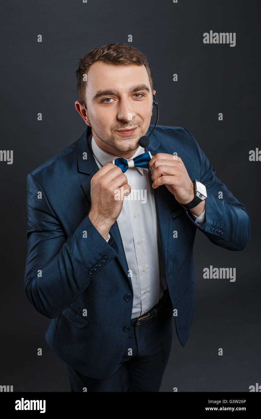 Schöne Moderatorin Mann im blauen Anzug und Fliege mit mic Blick in die ...