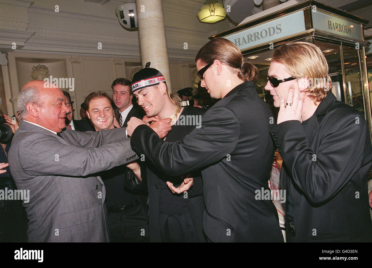 Harrods-Chef Mohammed Al Fayed knüpft eine Halskette um den Hals von Shane Lynch, einem der ...