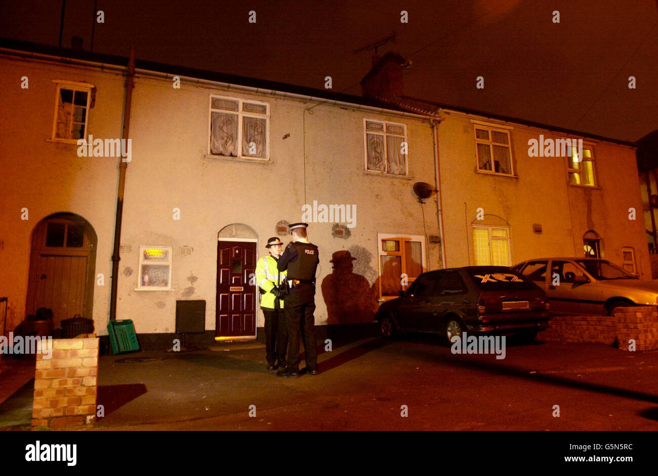Ein Polizist steht vor einem Haus in Tipton, West Midlands, das ...