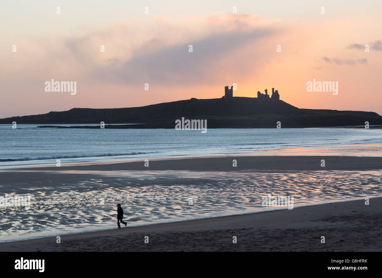 Die Sonne geht über Dunstanburgh Castle, Embleton Bay in Northumberland ...