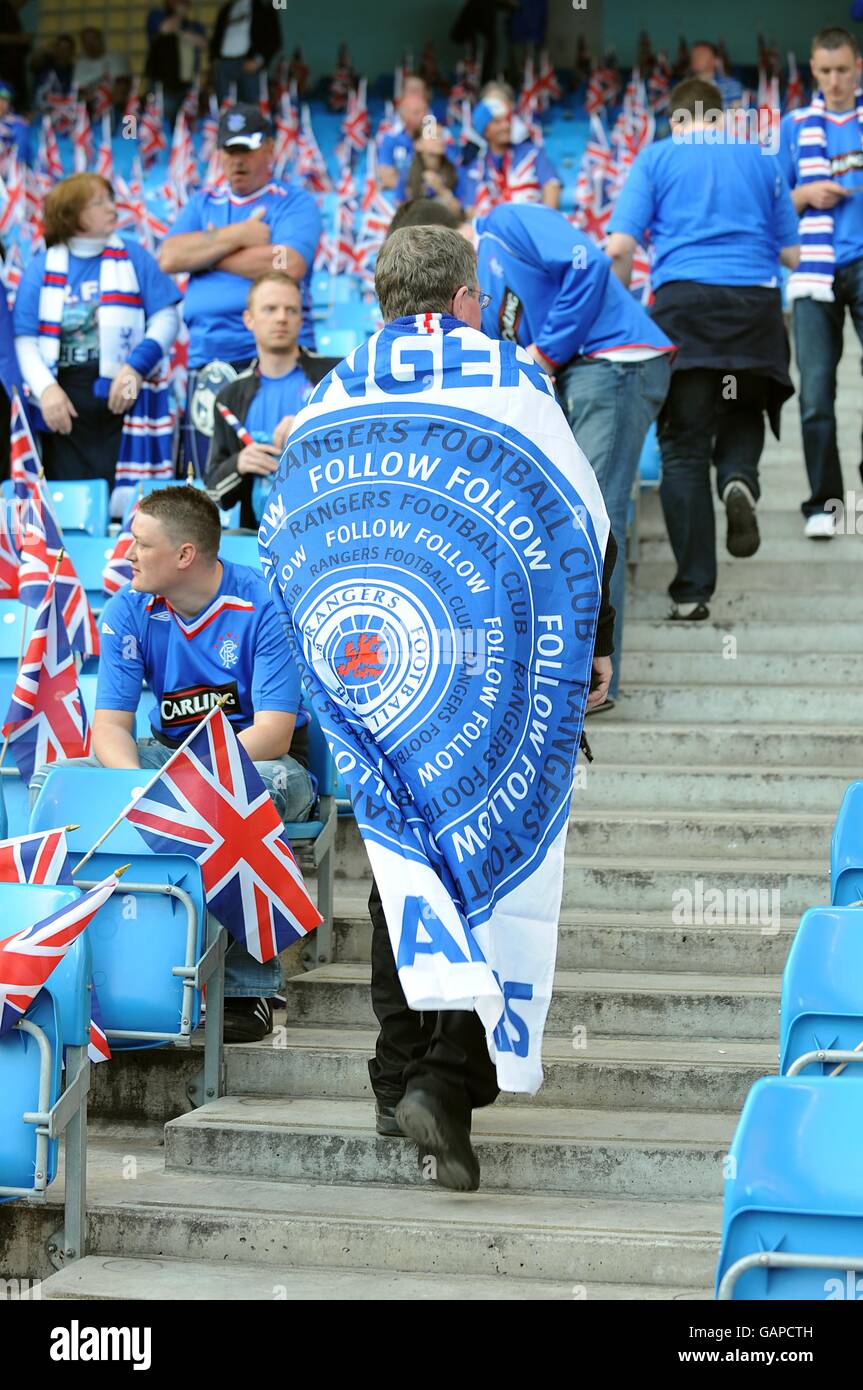 Ein Rangers-Fan setzt sich in die Tribüne und trägt eine Flagge mit dem ...
