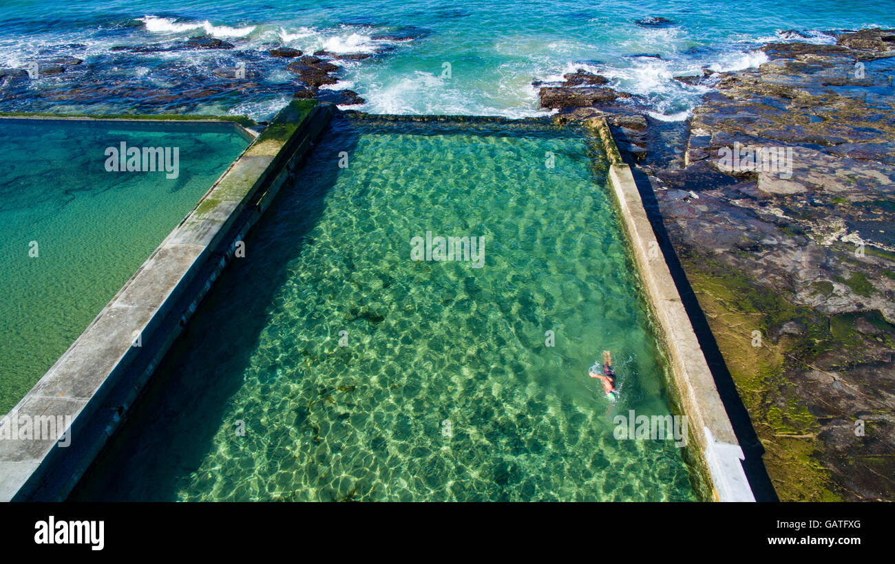 Ein einsamer Schwimmer schwimmt Runden im Austinmer Ozean Fels-Pools ...