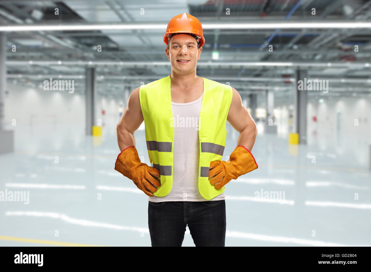 Fröhliche männliche Arbeiter mit einem orange Helm und grüne Warnweste ...