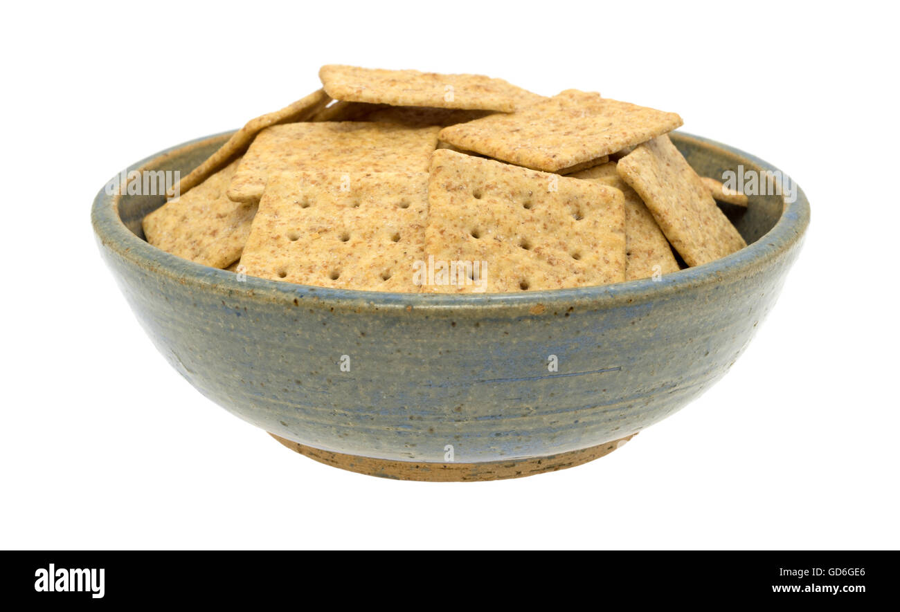 Eine alte Steinzeug Schale gefüllt mit Bio Vollkorn Cracker isoliert ...
