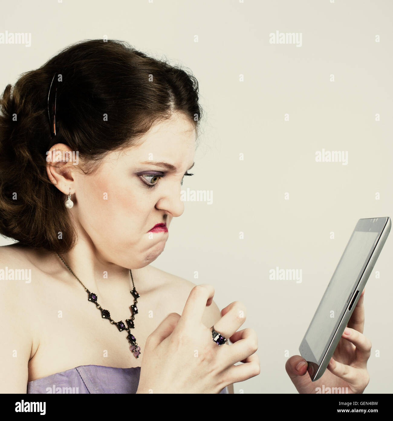 Frustrierte junge Frau nutzt Tablet und macht eine Gesicht-Square ...