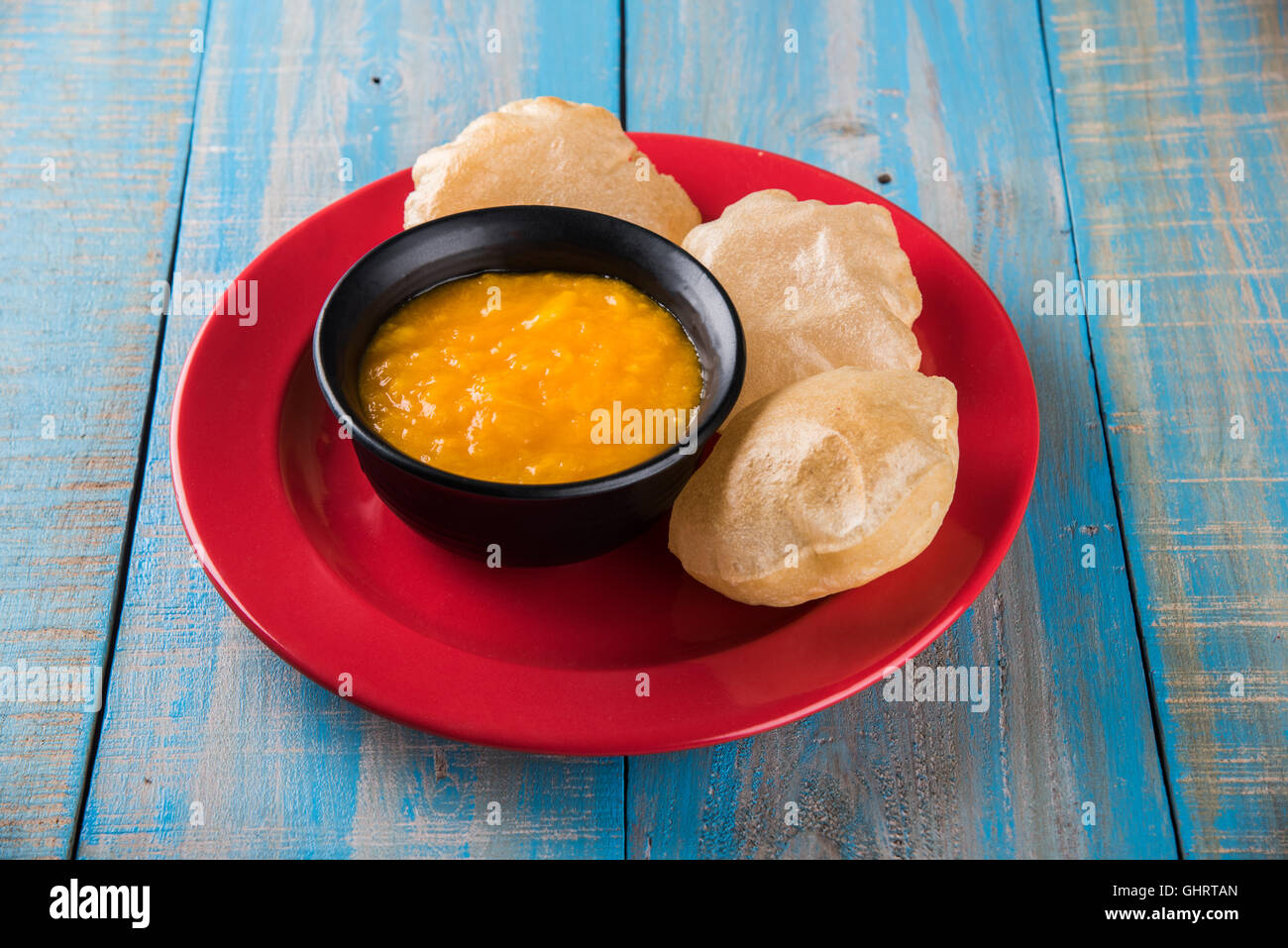 Aamras oder Aam Ras Puri: Puri ist eine indische gebratene kleine Brot ...