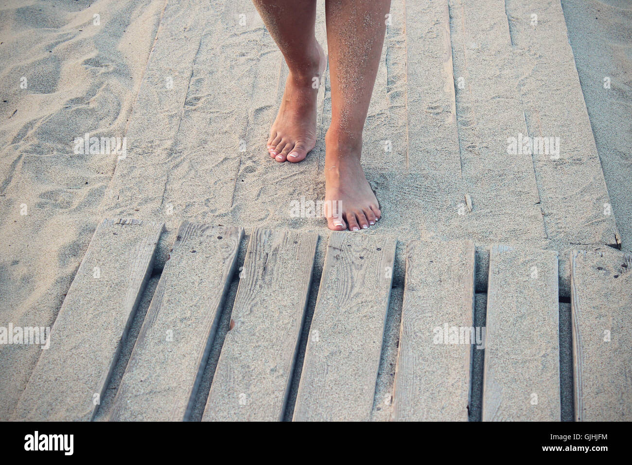 Frau barfuss entlang Holzdeck am Strand Stockfotografie - Alamy