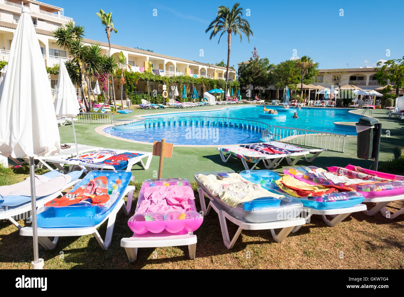 Handtücher auf Sonnenliegen rund um den Pool morgens von Touristen ...