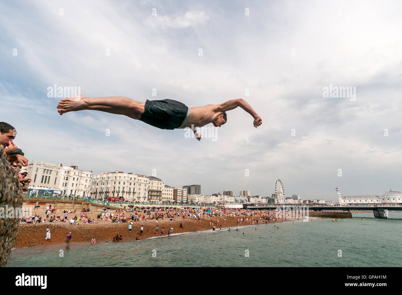 Jugendliche, Tauchen und springen ins Meer aus einer Buhne auf Brighton ...